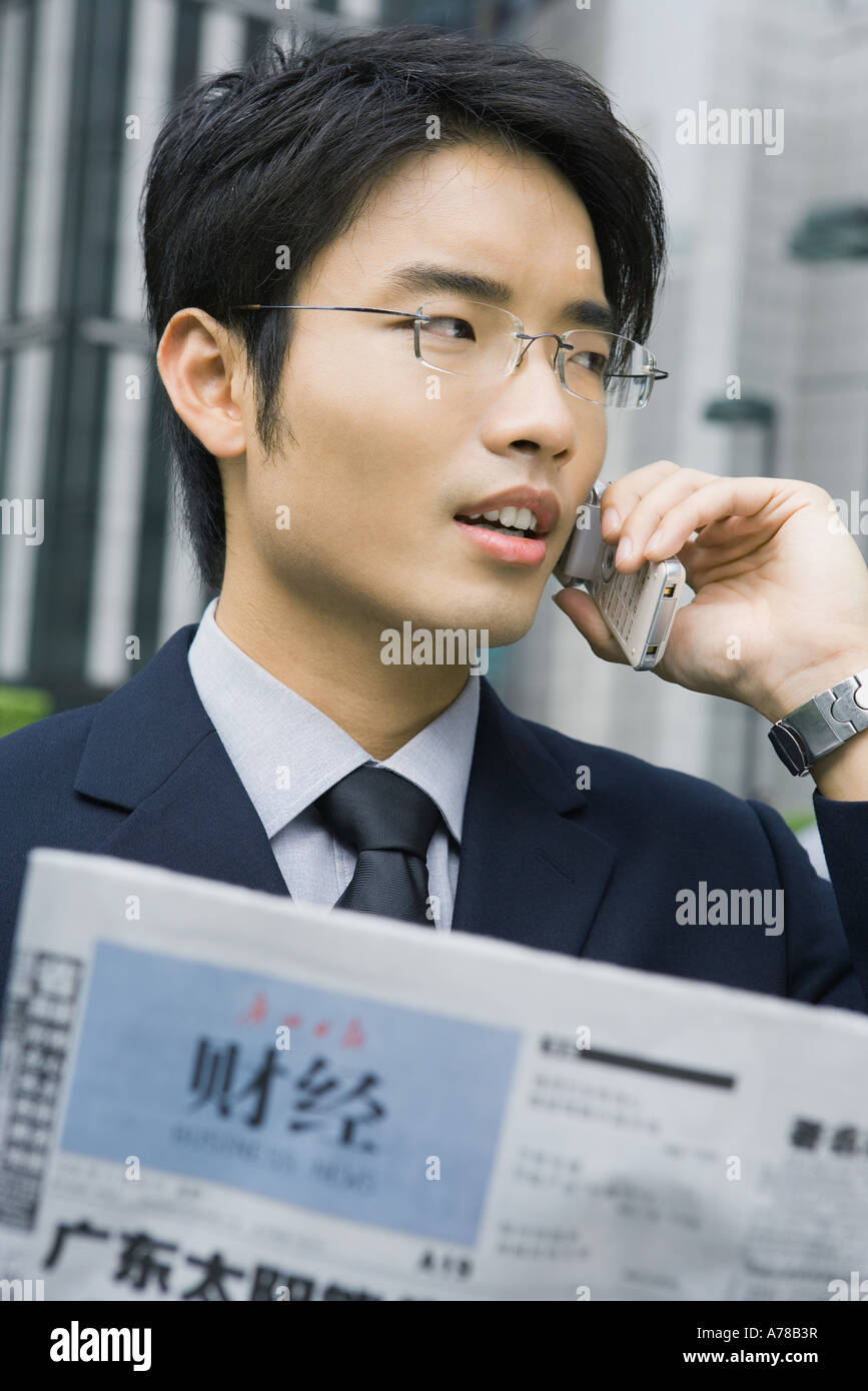 Businessman holding Chinese newspaper, using cell phone Stock Photo - Alamy Businessman holding Chinese newspaper, using cell phone Stock Photo - Alamy