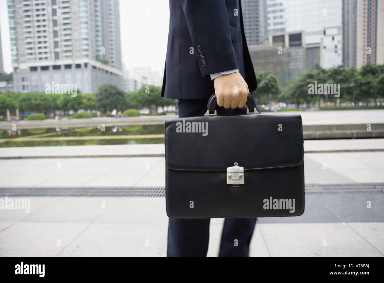 Businessman carrying briefcase, mid section Stock Photo - Alamy