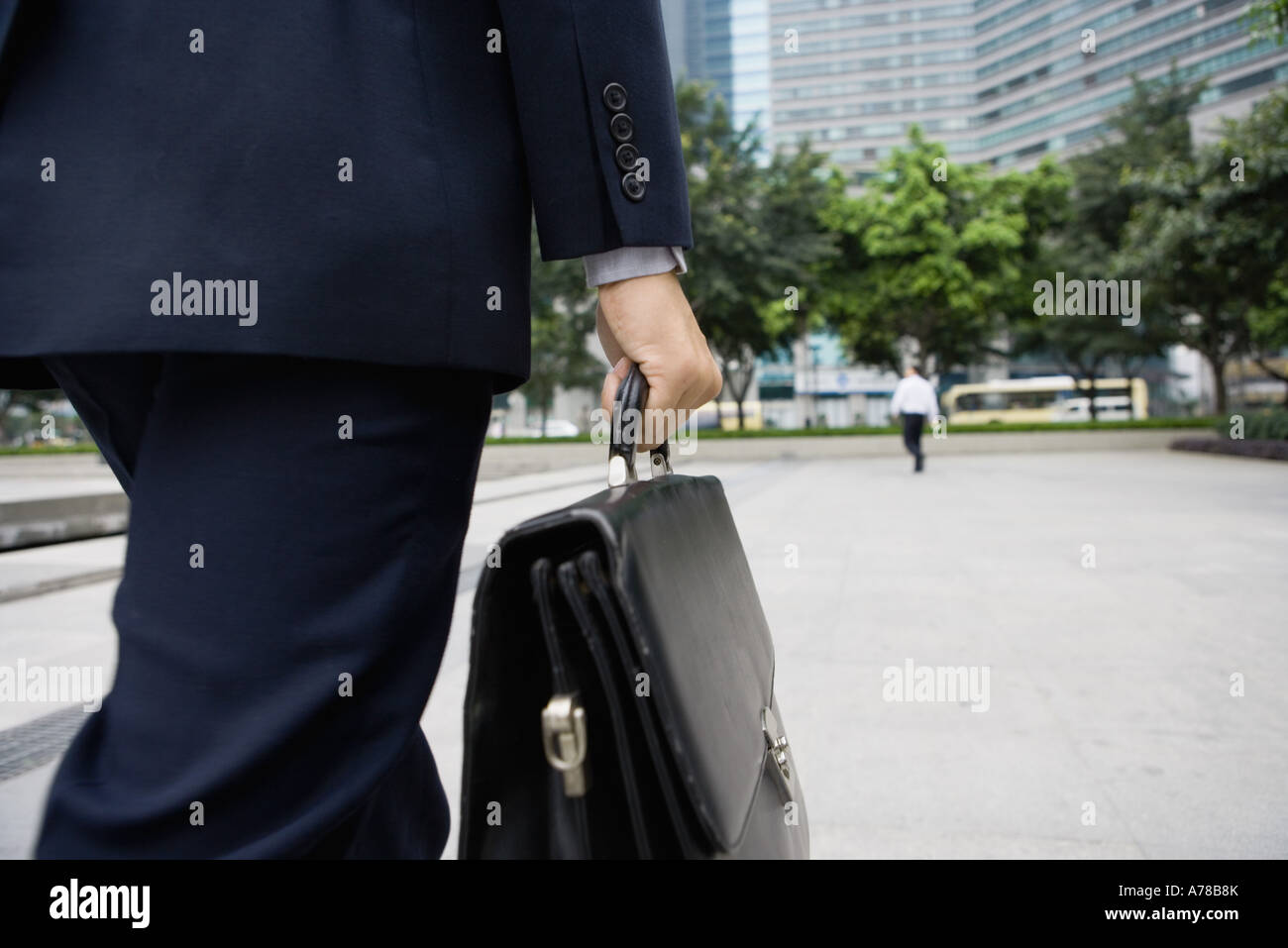 Businessman carrying briefcase, mid section Stock Photo - Alamy