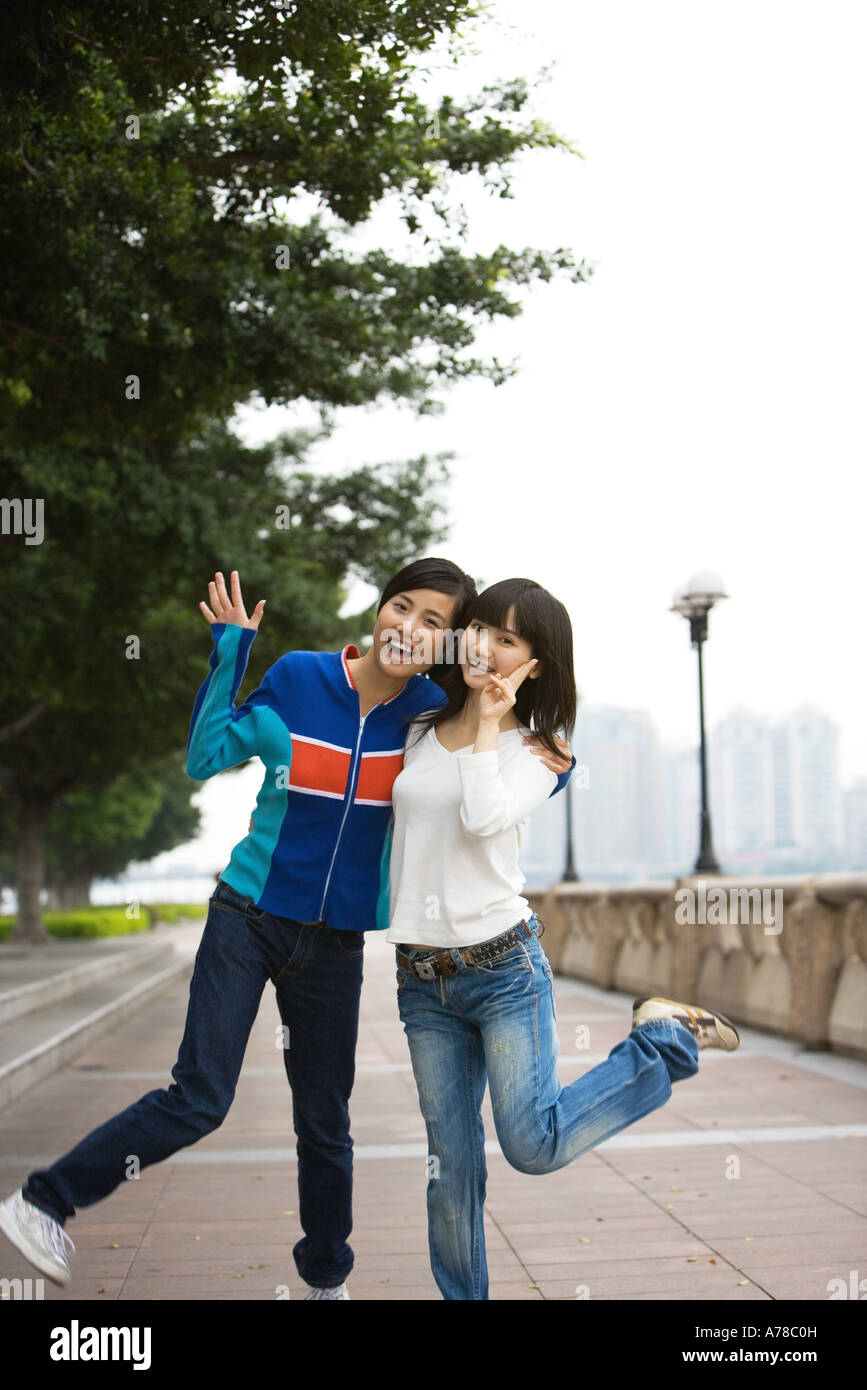 Two young adult female friends, both kicking one leg up Stock Photo - Alamy
