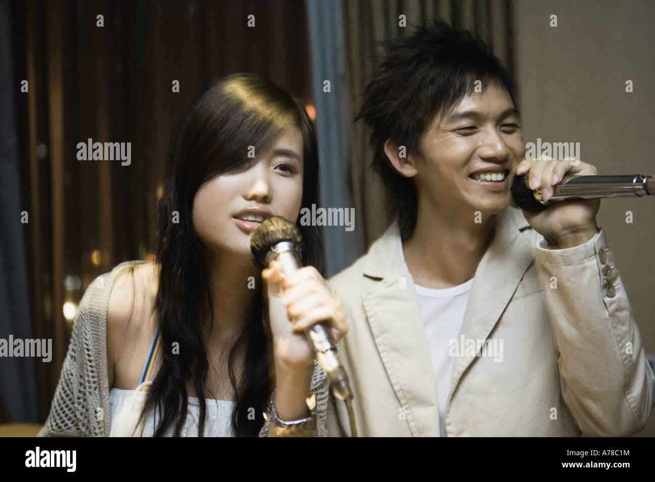 Young couple singing karaoke Stock Photo - Alamy