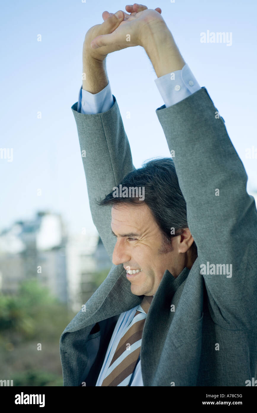 Businessman stretching arms over head Stock Photo - Alamy