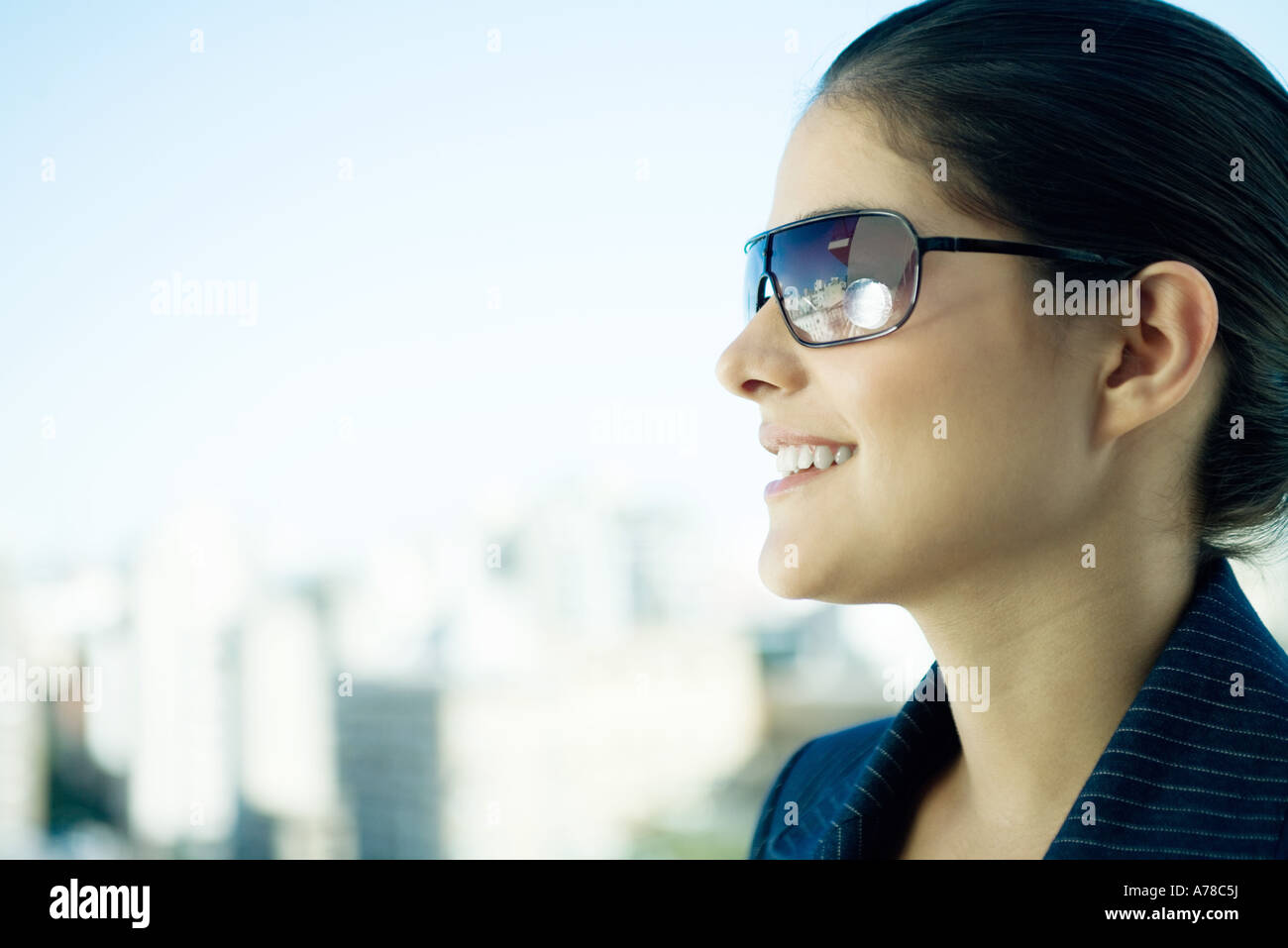 Woman wearing sunglasses, skyline in background, profile Stock Photo ...