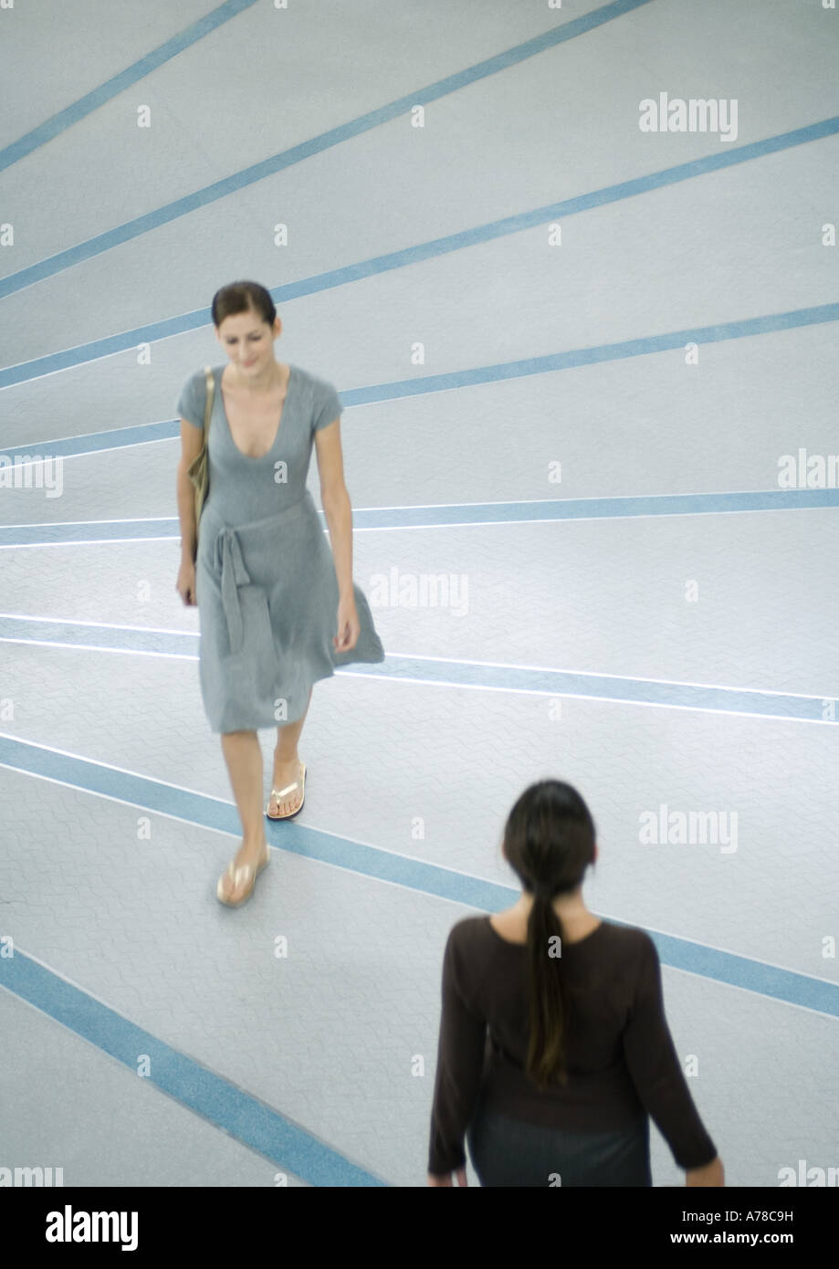 Two women walking by each other Stock Photo - Alamy