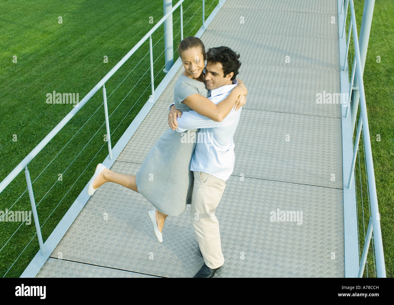 Couple on walkway, man spinning woman around in his arms Stock Photo ...