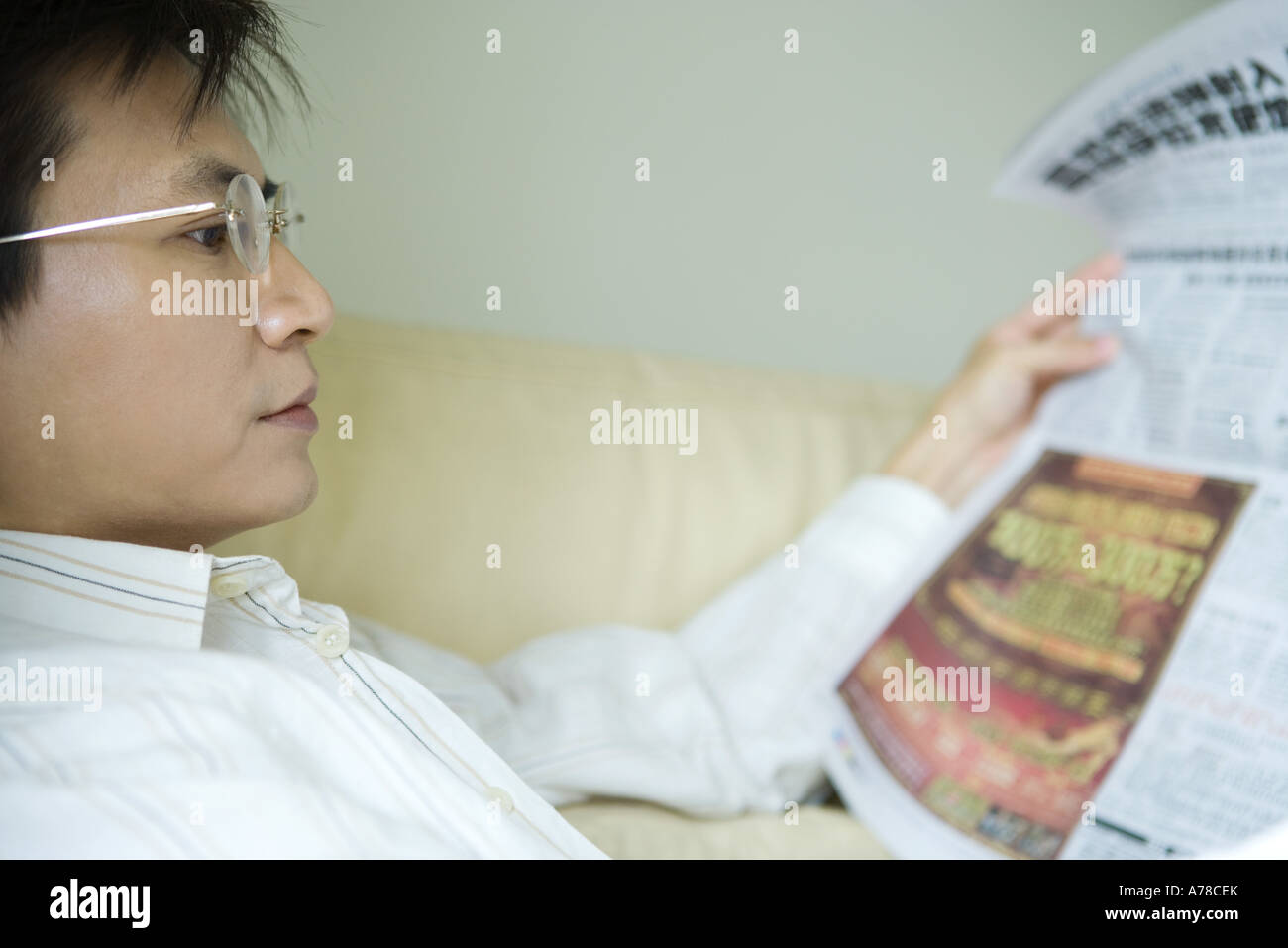 Man reading newspaper, side view Stock Photo - Alamy