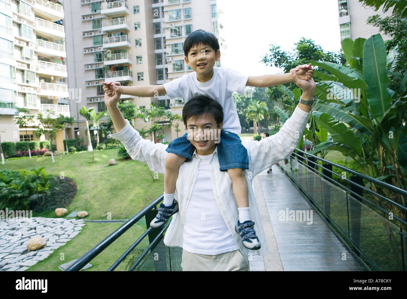 Boy riding on father's shoulders, front view, smiling at camera Stock ...