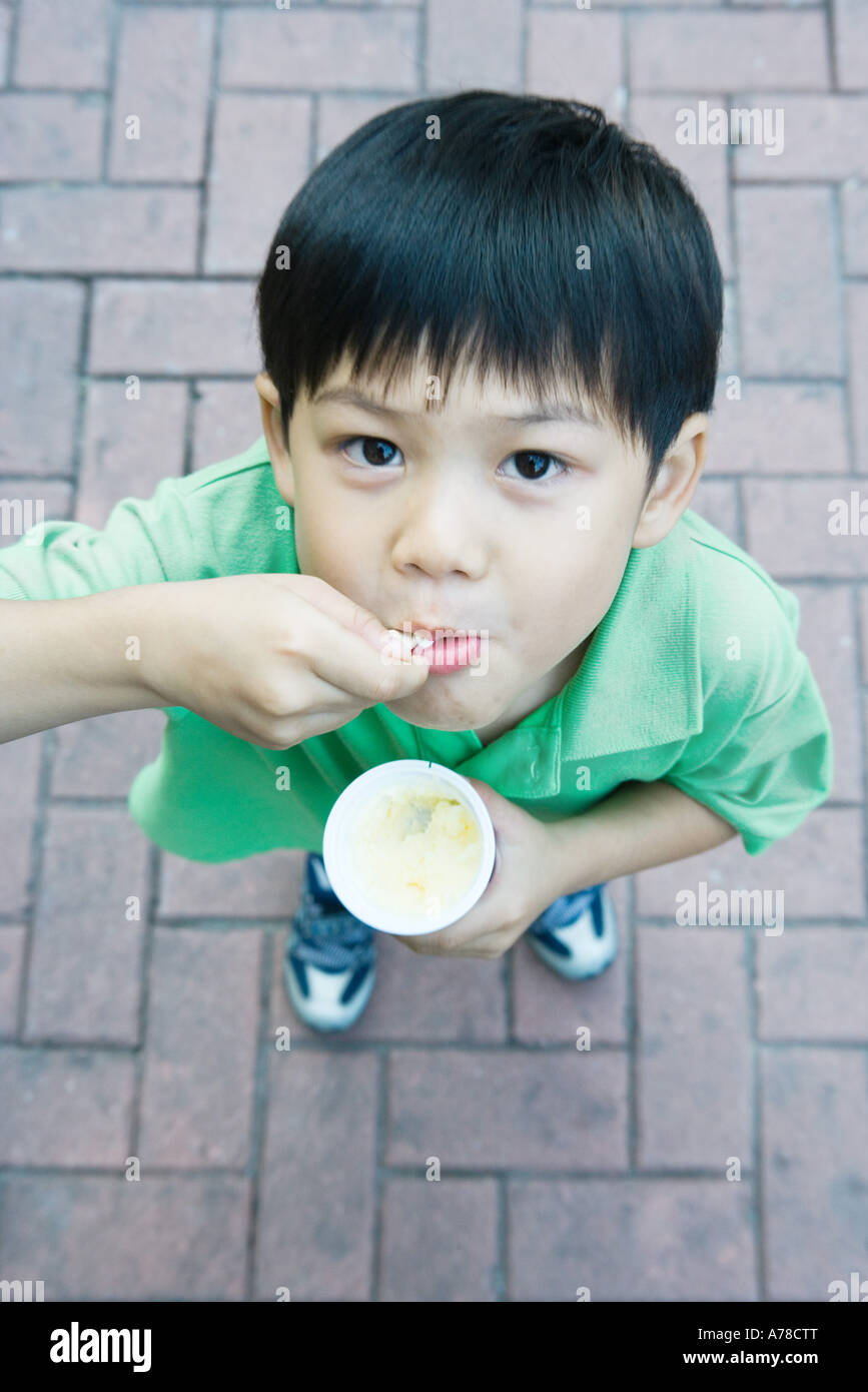 Boy eating sweet snack, smiling at camera Stock Photo - Alamy