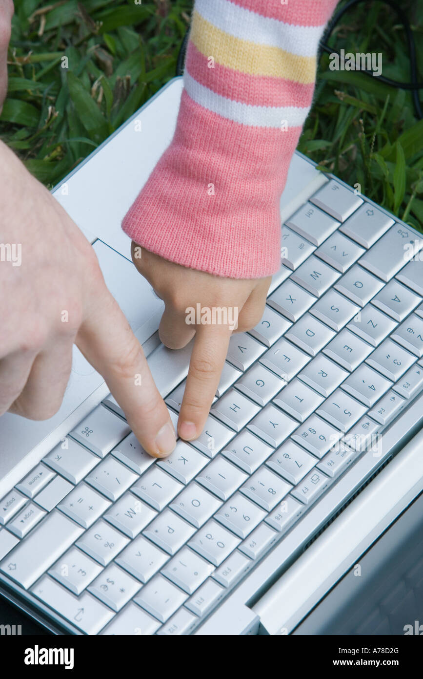 Child and adult hands pressing keys on keyboard Stock Photo - Alamy