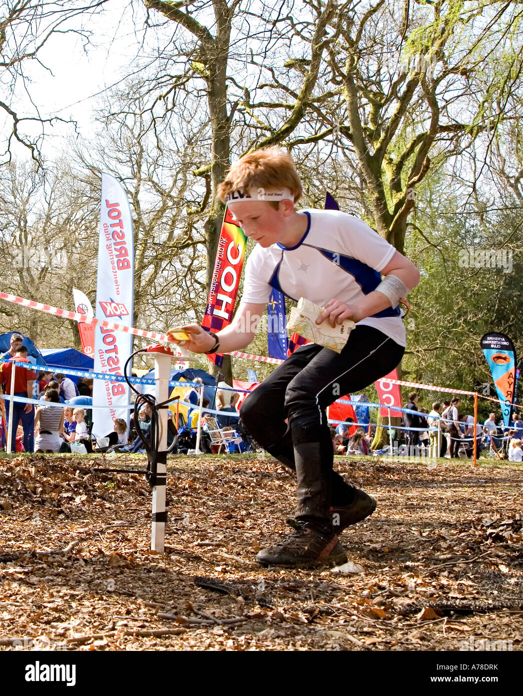 Young boy crossing the finishing line with his e card tag orienteering ...