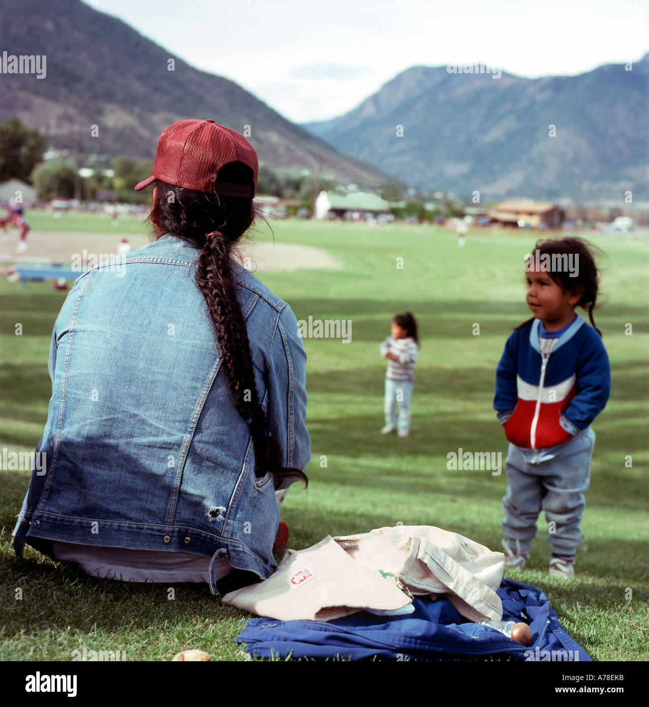 A First Nation Indian child at the baseball park with her father ...