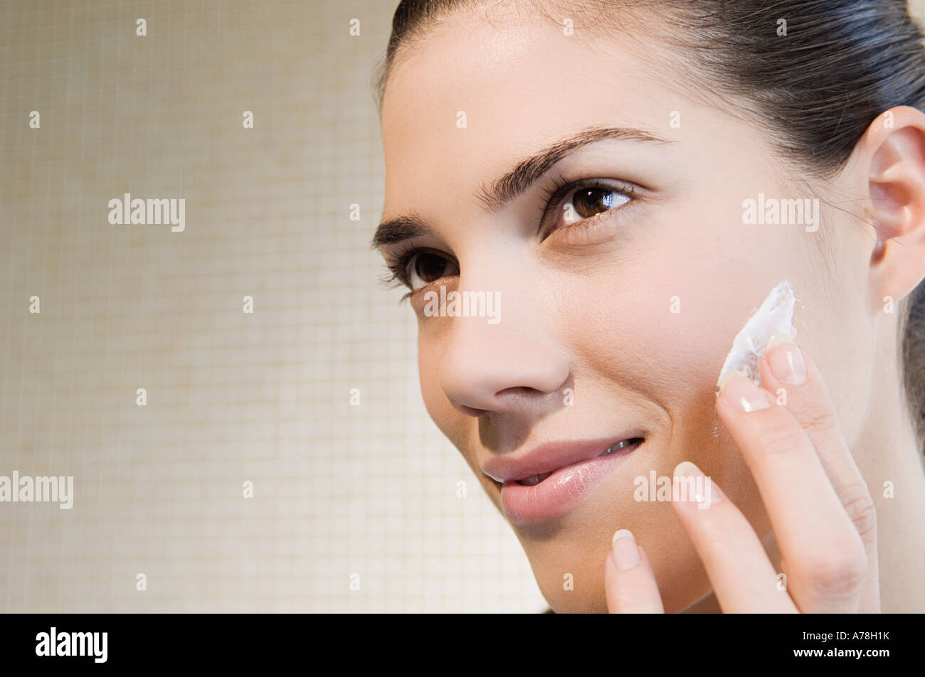 Woman applying moisturiser Stock Photo - Alamy