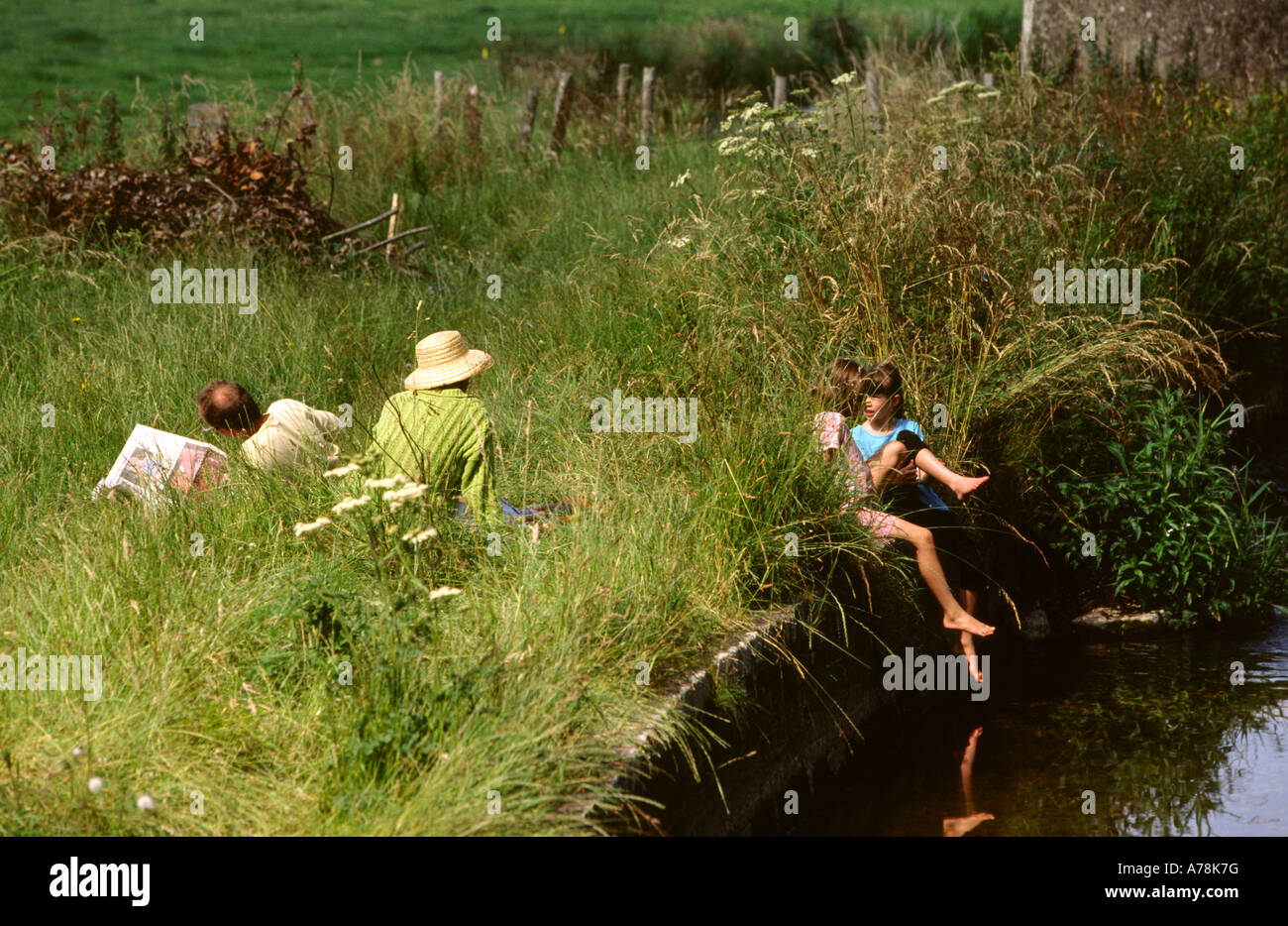 UK Dorset Lower Bockhampton family relaxing in meadow beside River ...