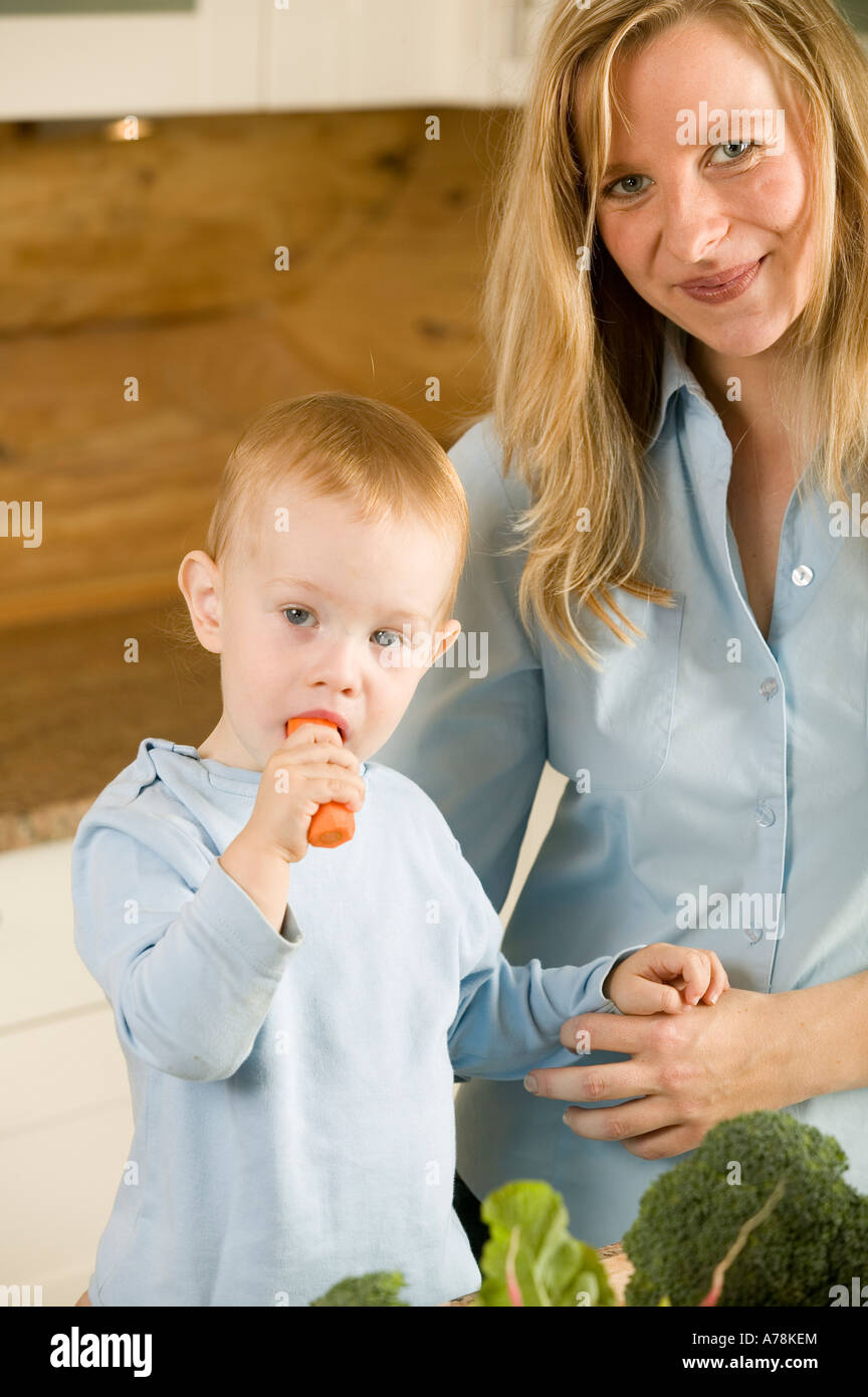 young mother and child cooking together in kitchen playing with organic ...
