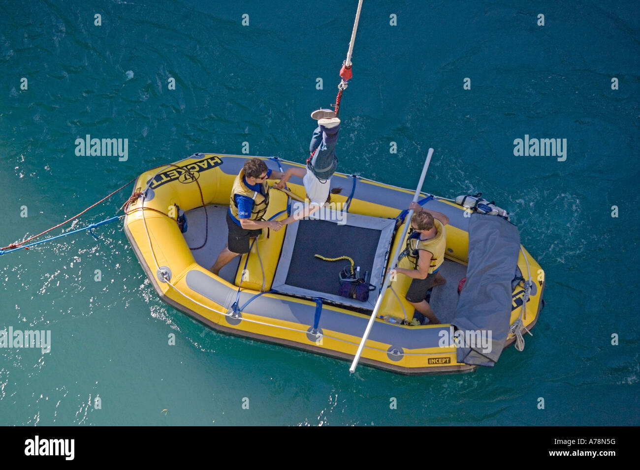 Woman being helping into dinghy after jumping from Kawarau Bridge Bungy ...
