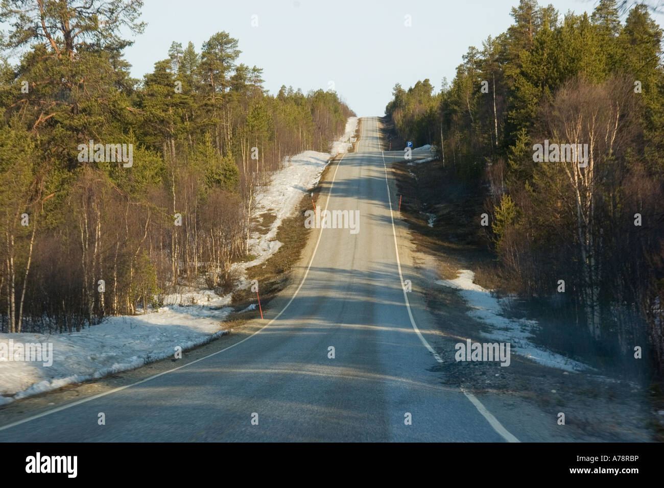 Long straight narrow bumpy road leading into the distance with tree ...