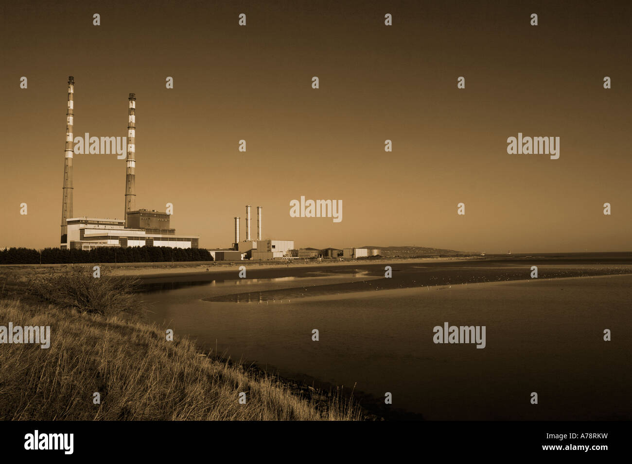 Sepia view of poolbeg power station and cooling towers in dublin bay ...