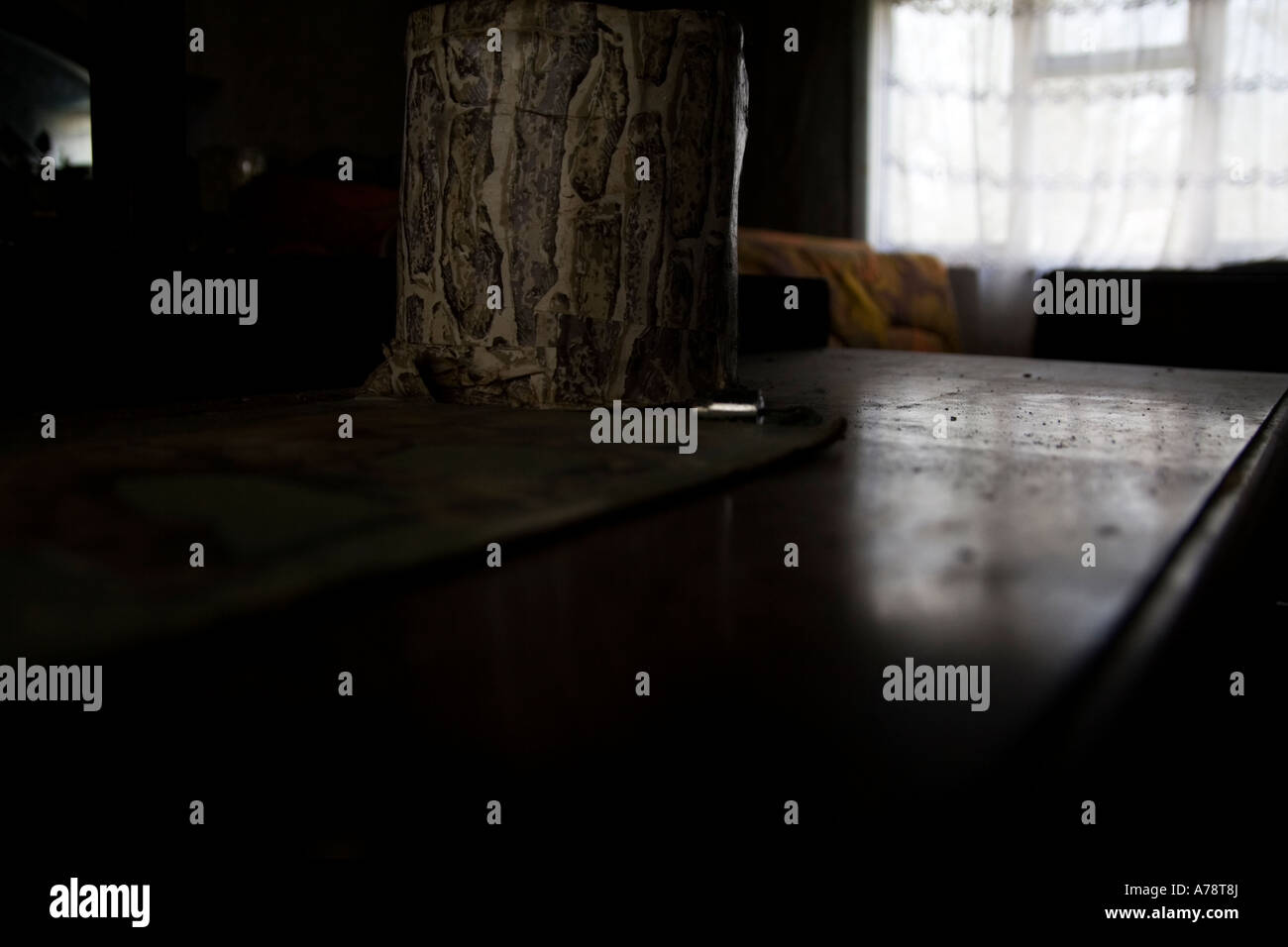 Dusty table reflecting the light shining in through a window in an old ...