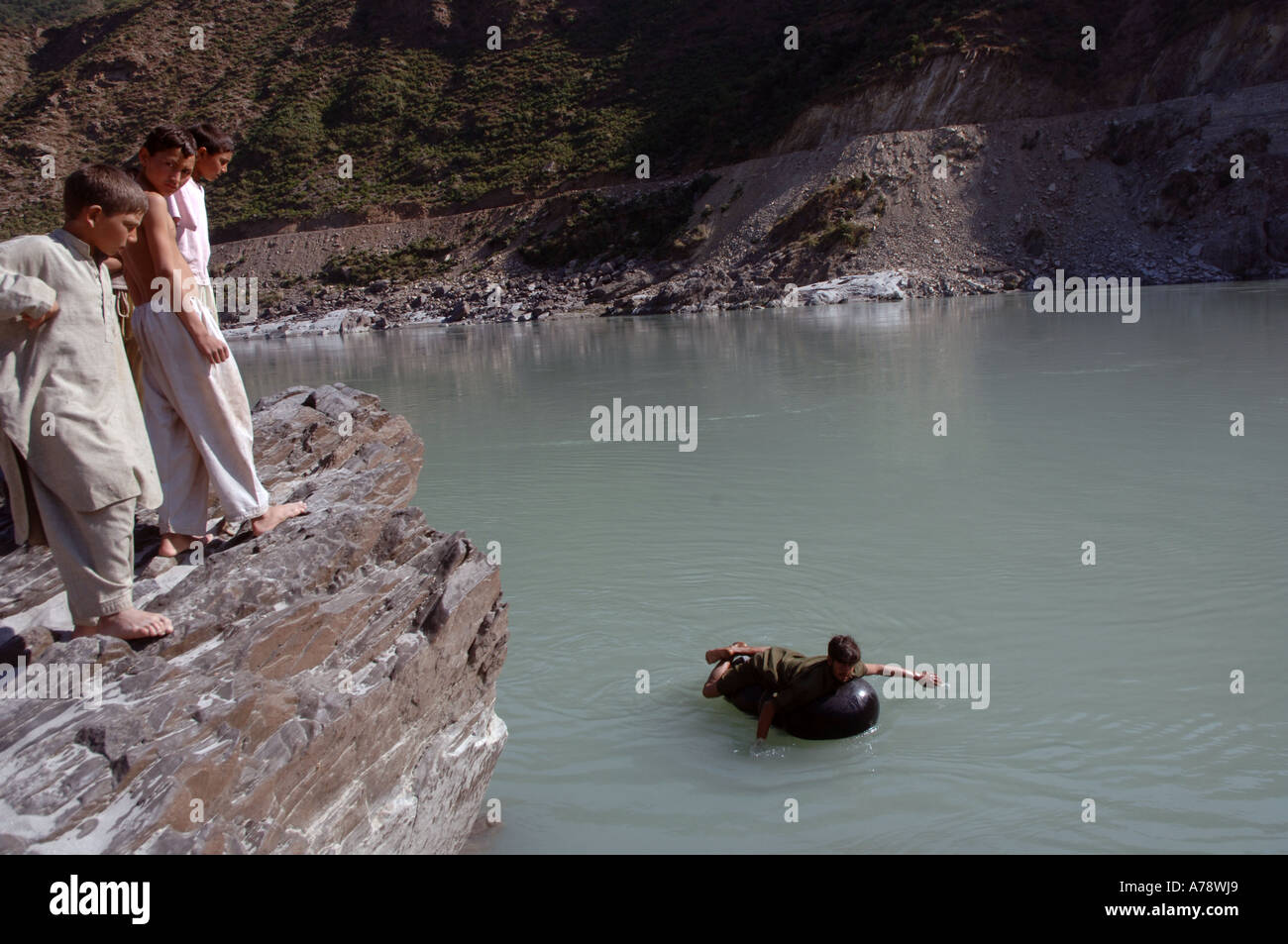 Women and children wash clothes in the river Indus, Allai valley ...