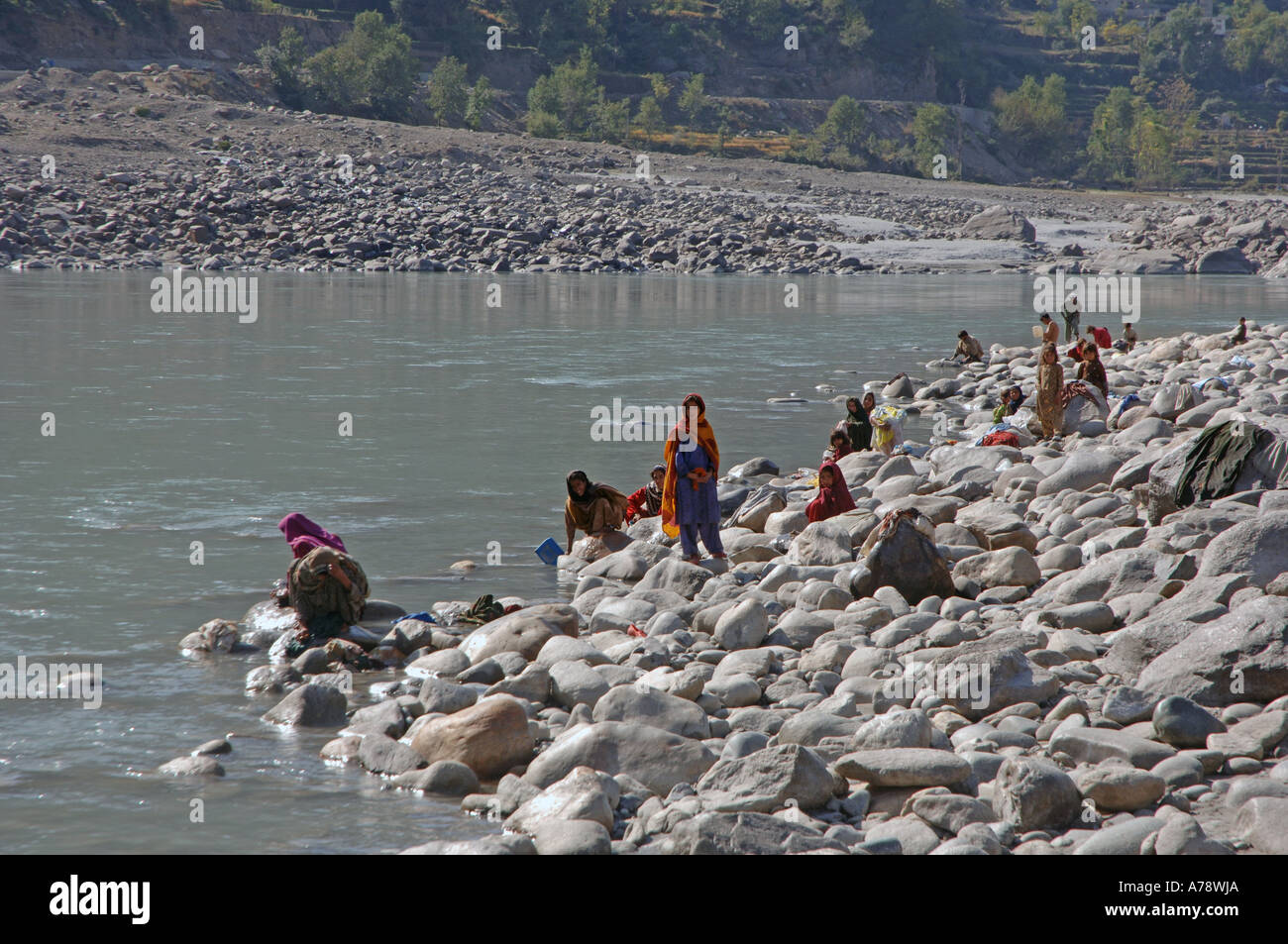 Women and children wash clothes in the river Indus, Allai valley ...