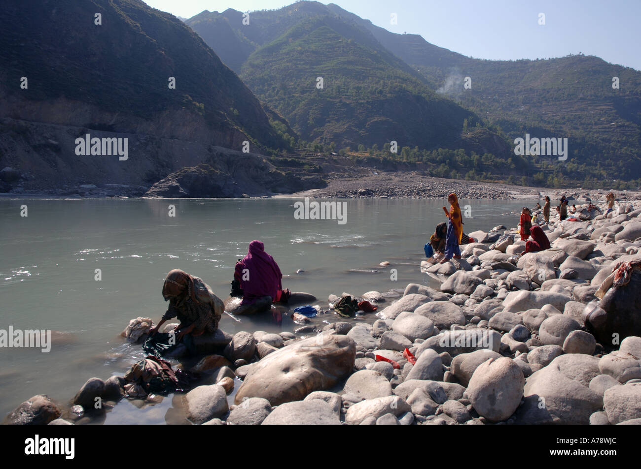 Women and children wash clothes in the river Indus, Allai valley ...