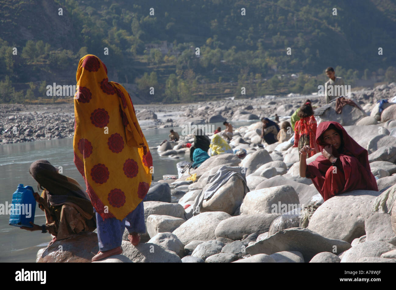 Women and children wash clothes in the river Indus, Allai valley ...