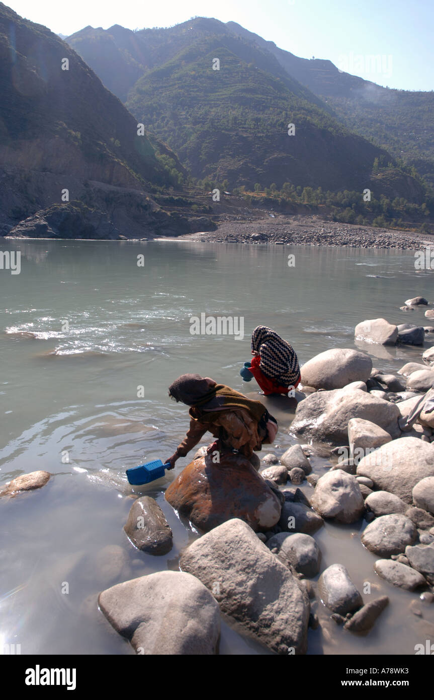 Women and children wash clothes in the river Indus, Allai valley ...