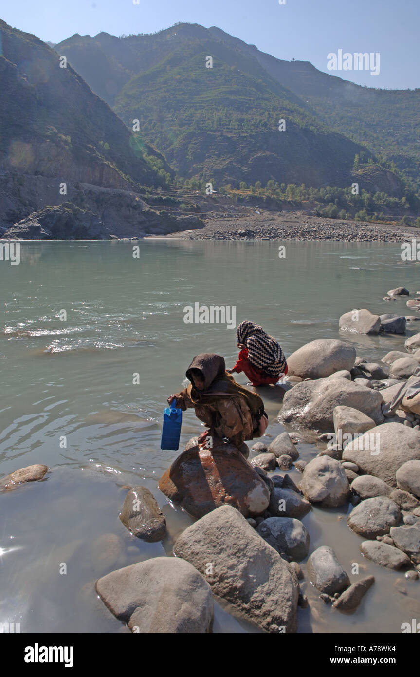 Women and children wash clothes in the river Indus, Allai valley ...