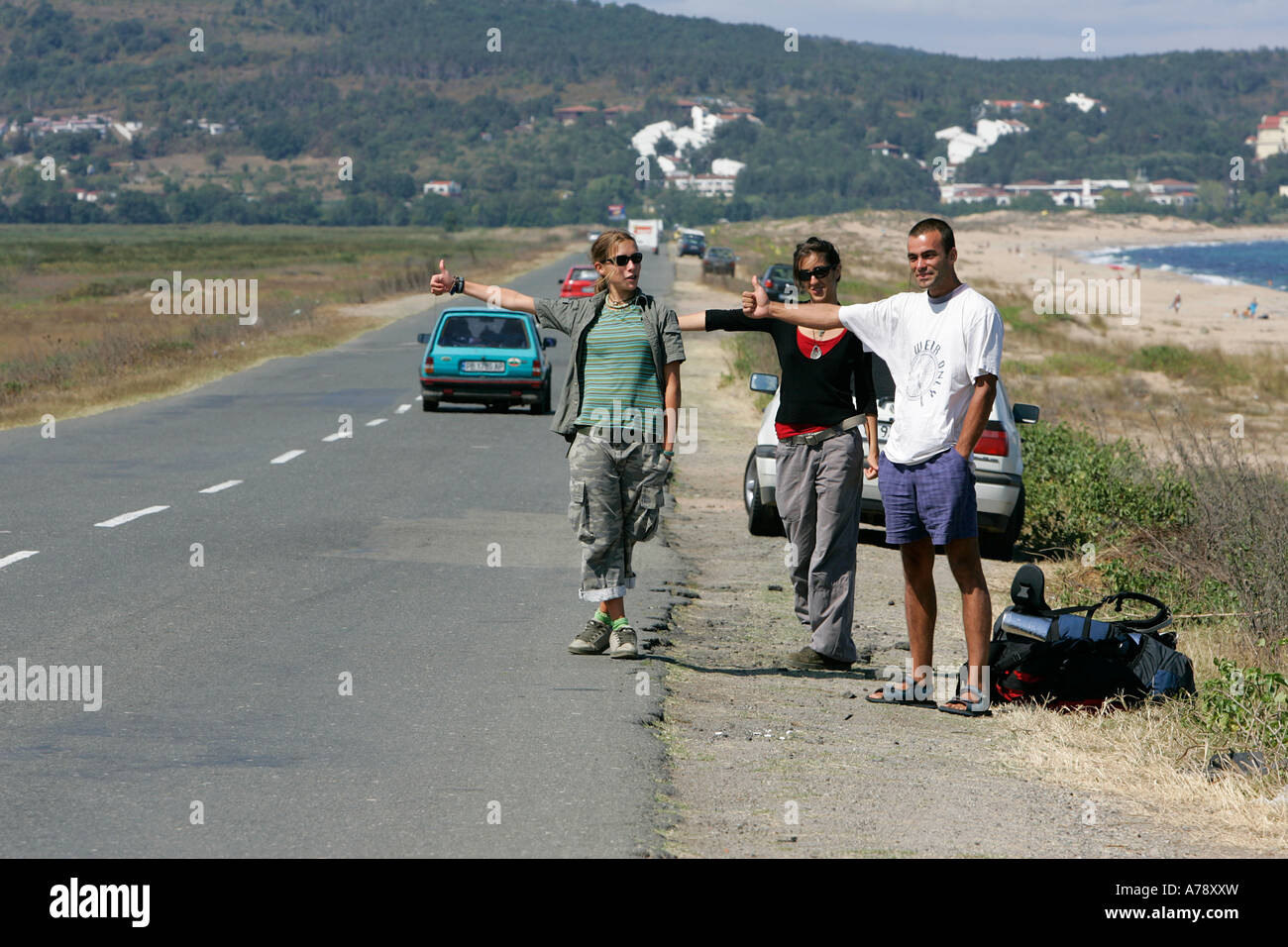 Teenage girl and boy hitch hiking Stock Photo - Alamy