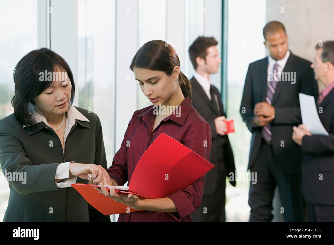 Businesswomen looking at file Stock Photo - Alamy