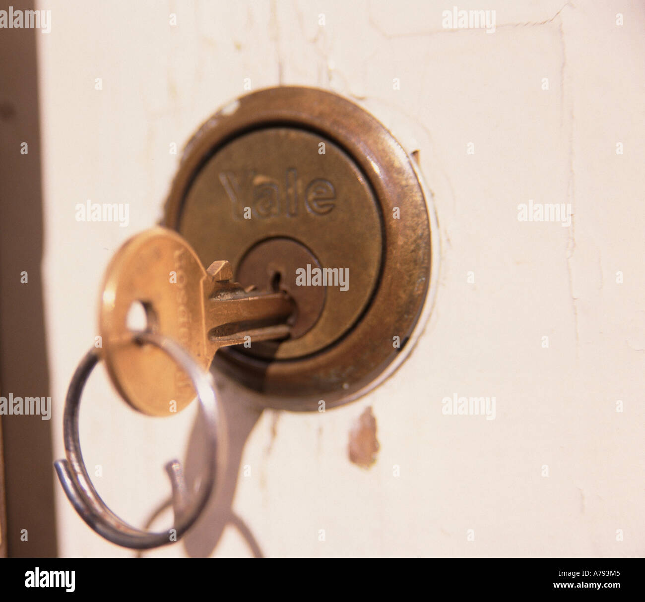 Yale house lock with key in white door Stock Photo - Alamy