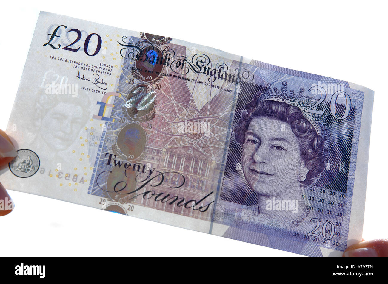 A new twenty pound note being held up to the light to check for ...