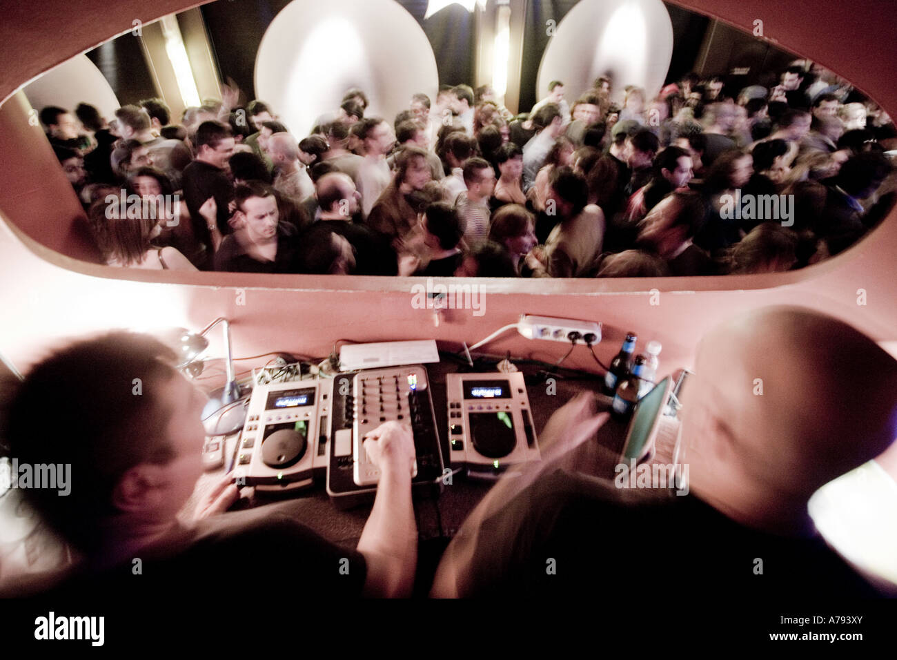 dj playing records and music in crowded disco bar night club full of ...