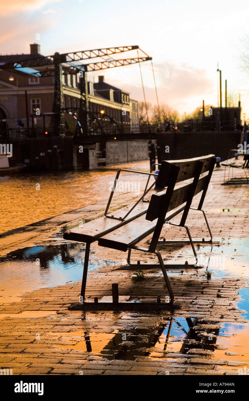bench and sunset on amsterdam canal after storm Stock Photo - Alamy