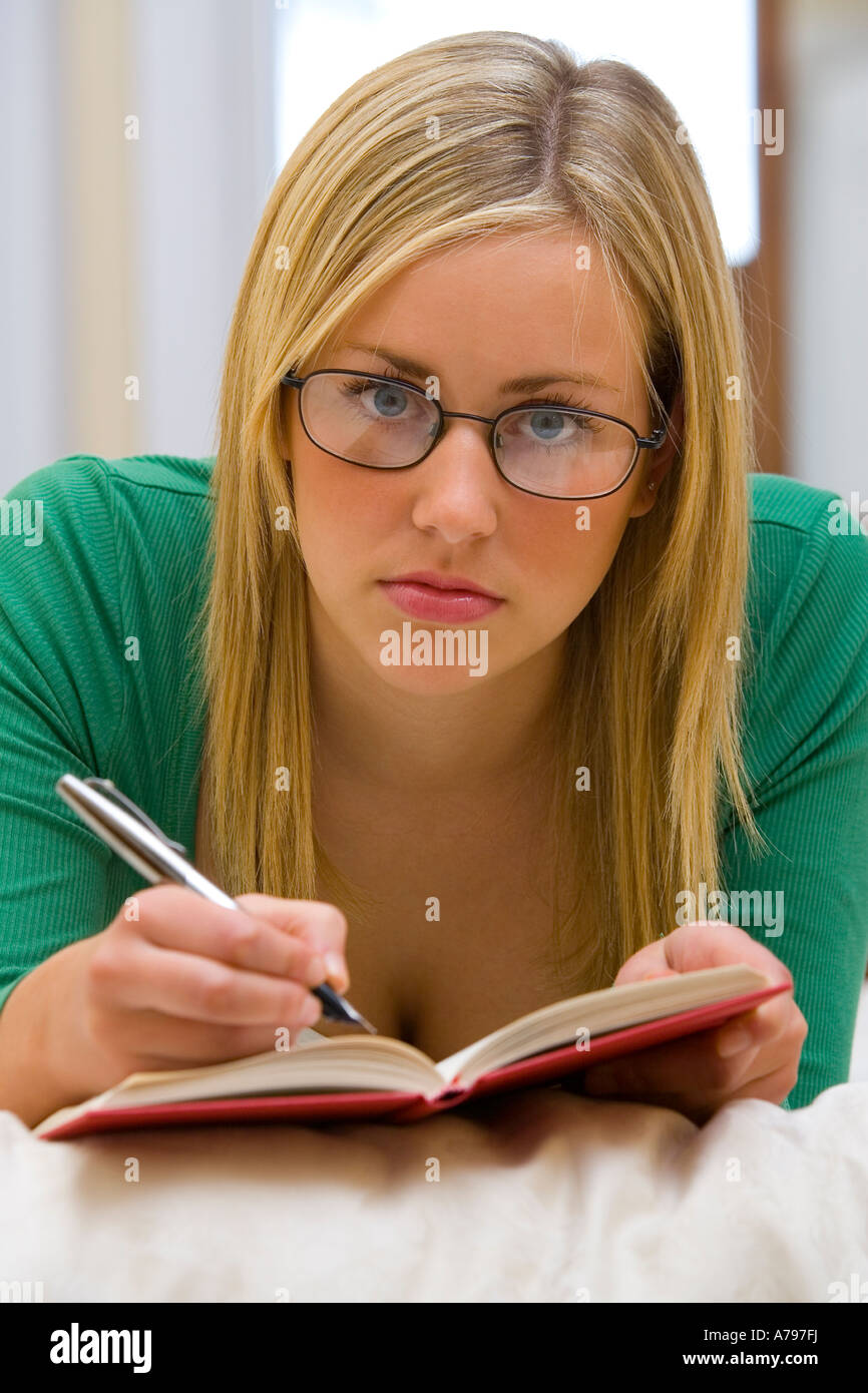 A beautiful young woman writing an entry in her diary Stock Photo - Alamy