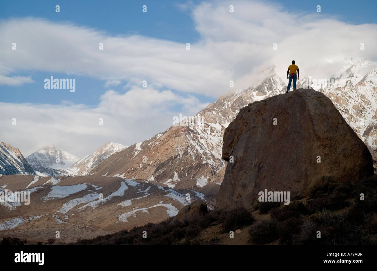 A man stands atop a boulder in the Buttermilks a climbing area near ...