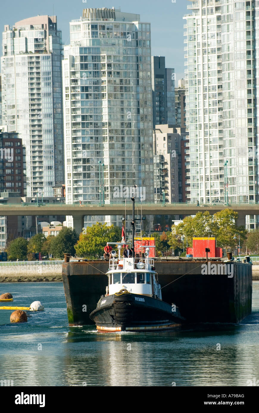 A tug pulls a barge into False Creek in downtown Vancouver BC Stock ...