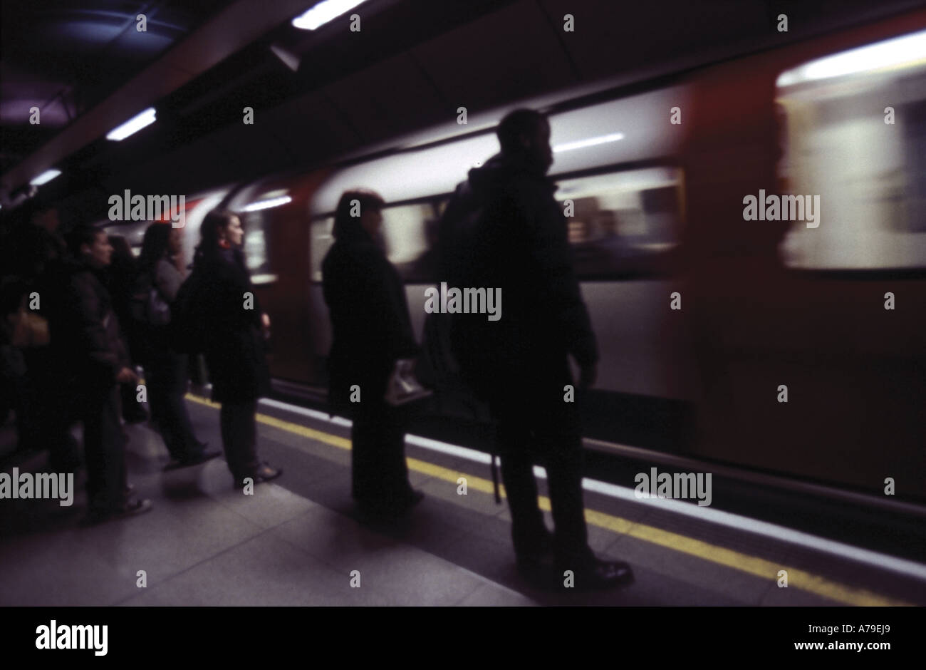 Commuters in London Underground Station waiting by moving train Stock ...