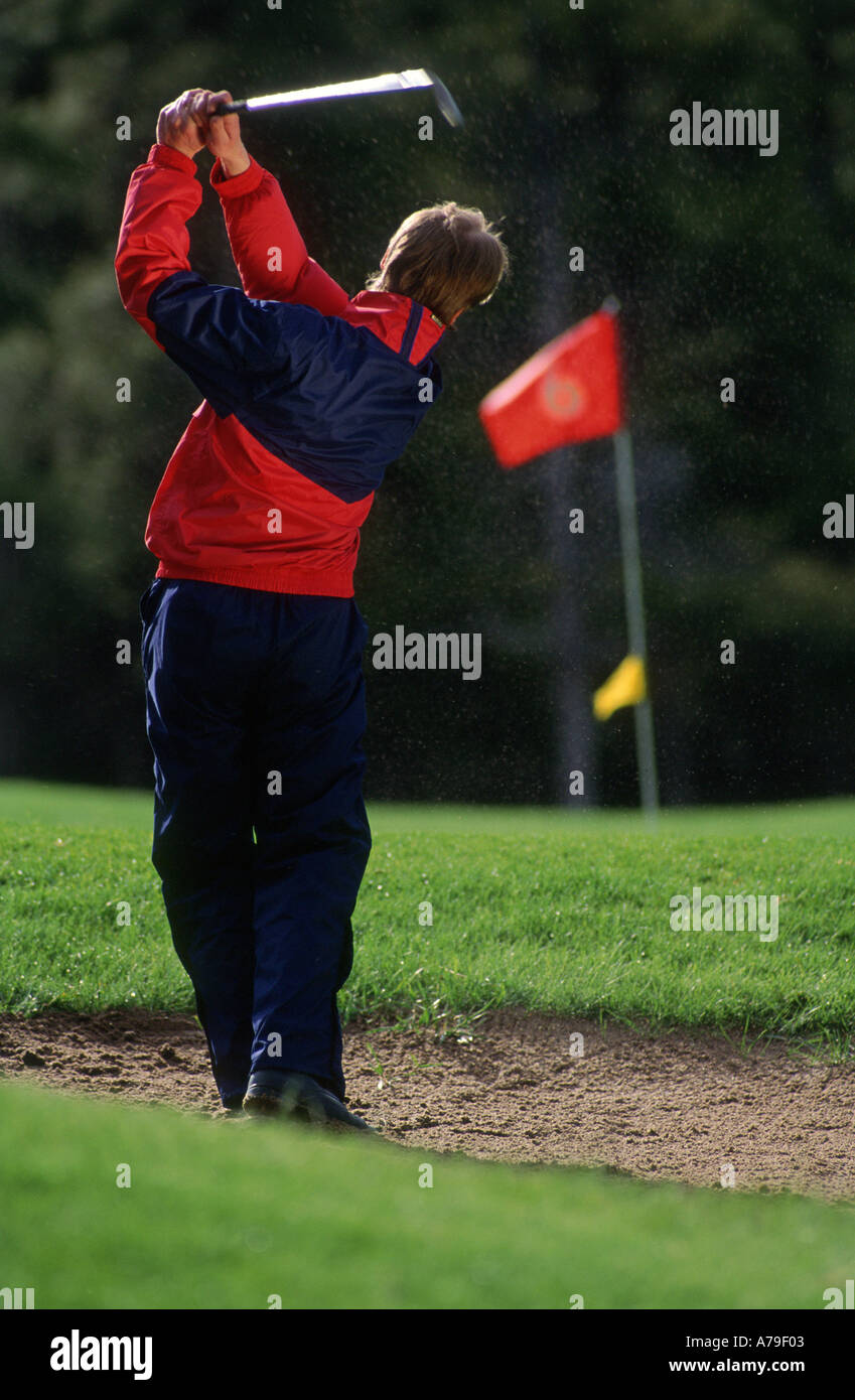 Male golfer chipping ball from the sand Stock Photo - Alamy
