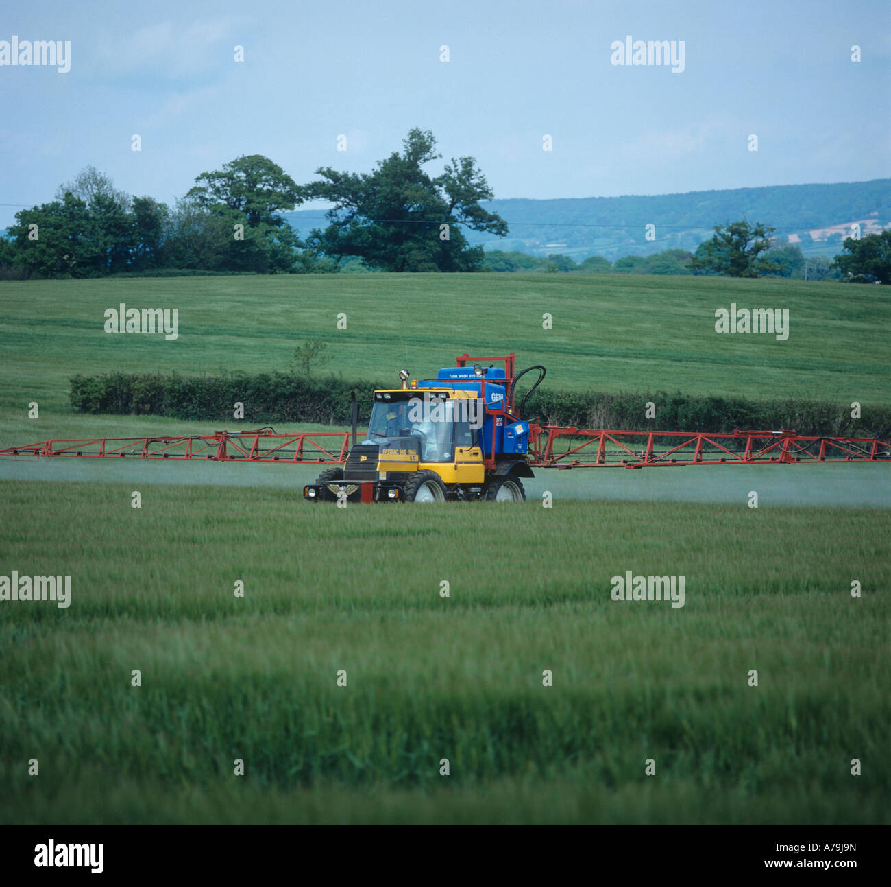 Fastrac tractor with mounted sprayer spraying barley crop in ear Devon ...