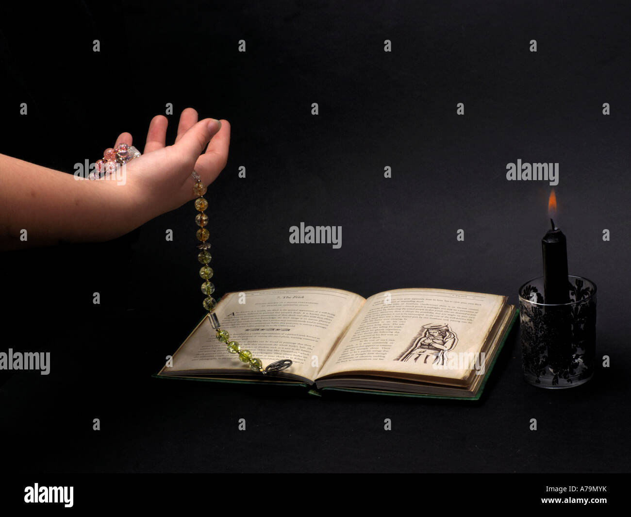 Hand Holding Witches Ladder , Candle & Spell Book Stock Photo - Alamy
