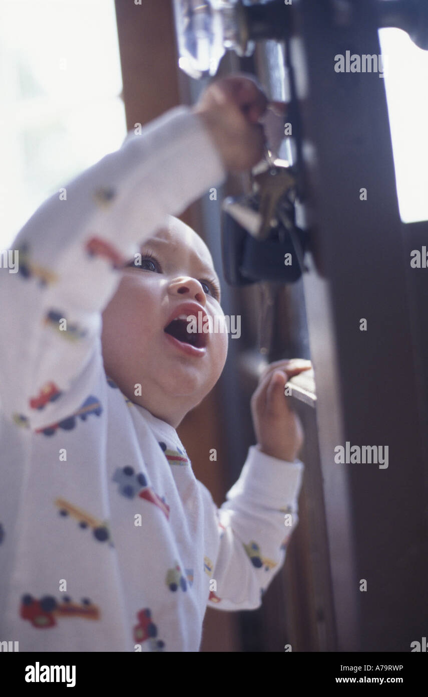 Baby in pajamas playing with keys unlocking door Stock Photo - Alamy