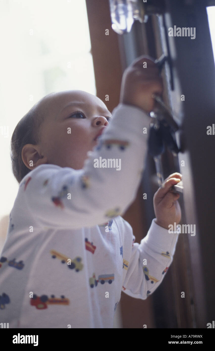 Baby with keys unlocking door Model Released Stock Photo - Alamy