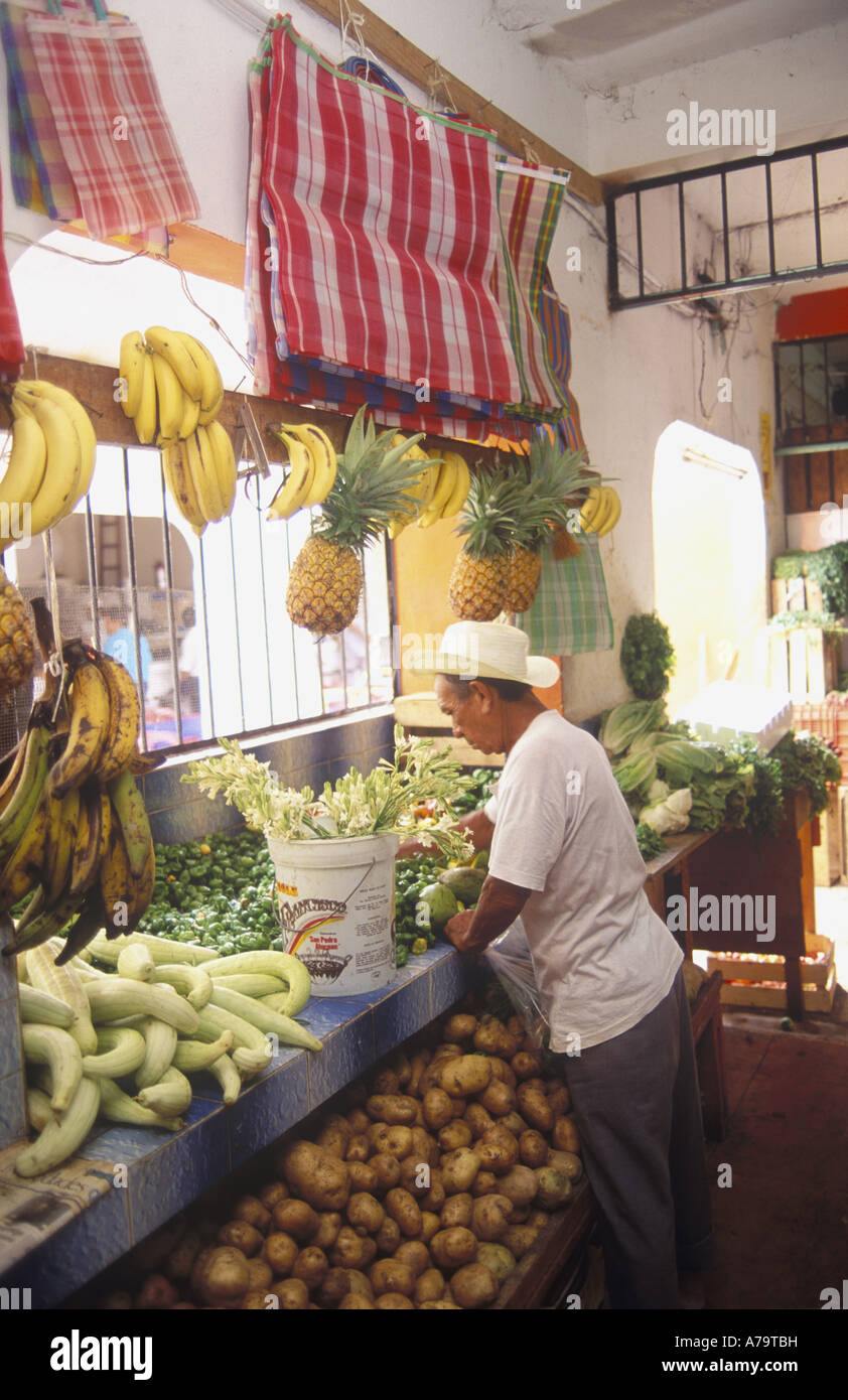 Market worker prepares fruit and vegetables at farmers market in Cancun ...