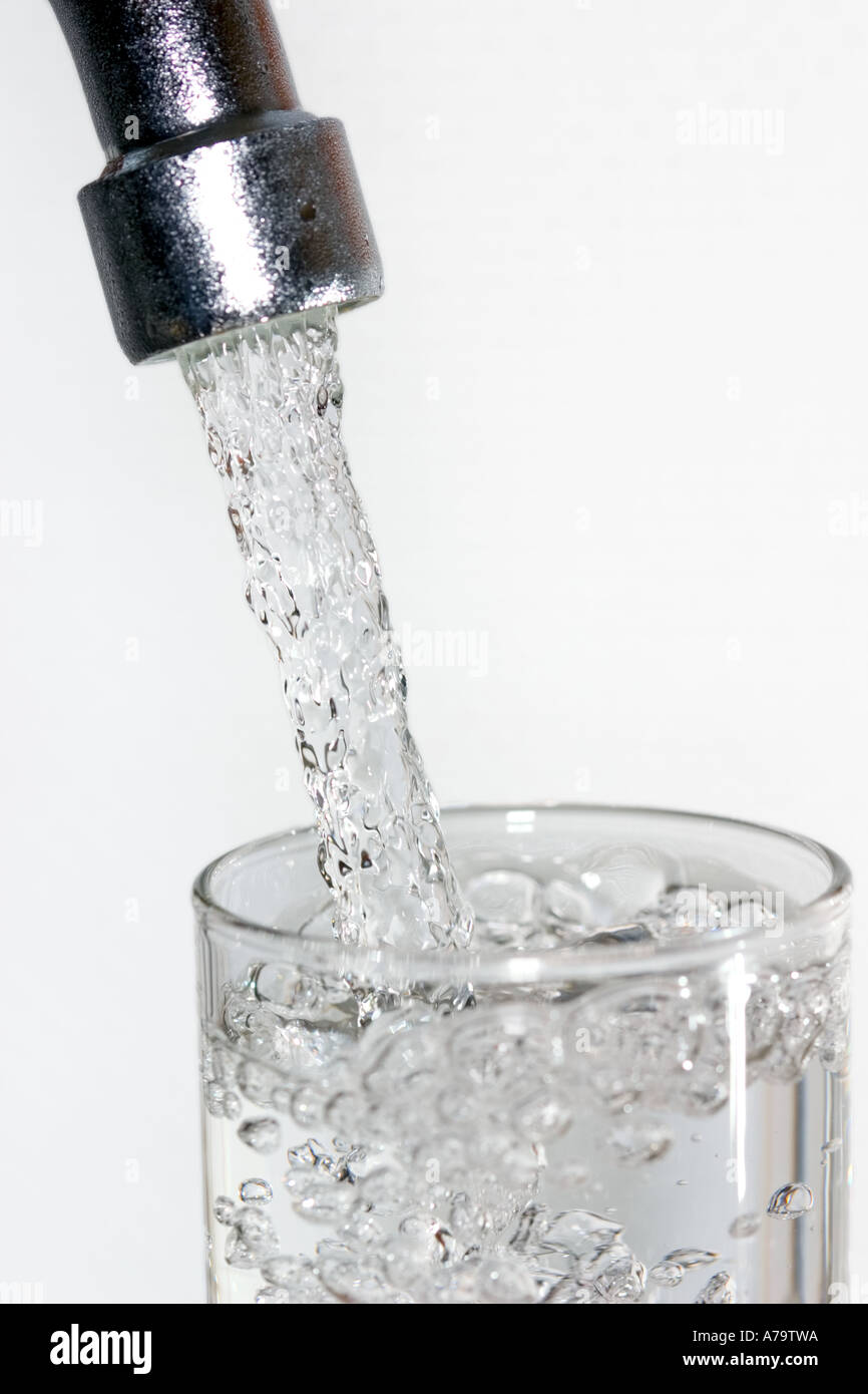 fresh water running from tap faucet into glass Stock Photo - Alamy