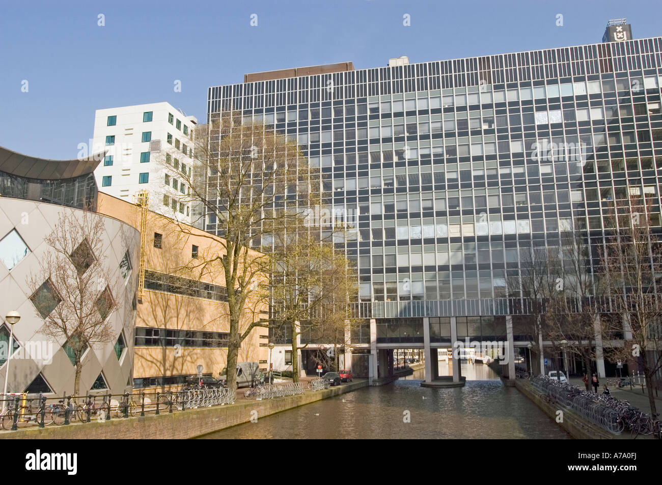 Modern building of Amsterdam University with water canal pass, Holland ...