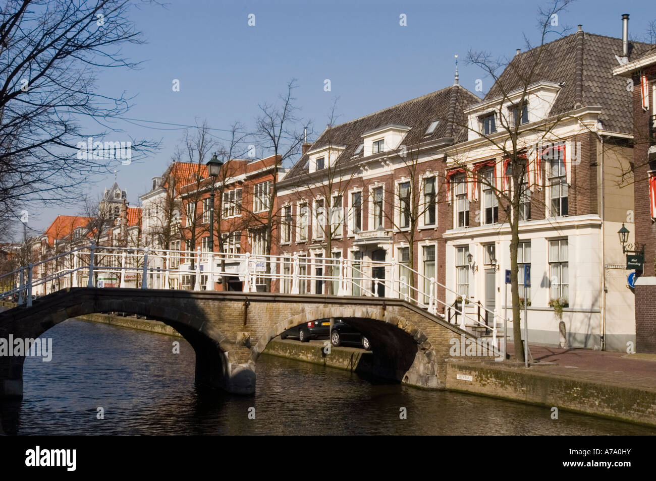 Small bridge over old canal in Delft with row of heritage buildings and ...