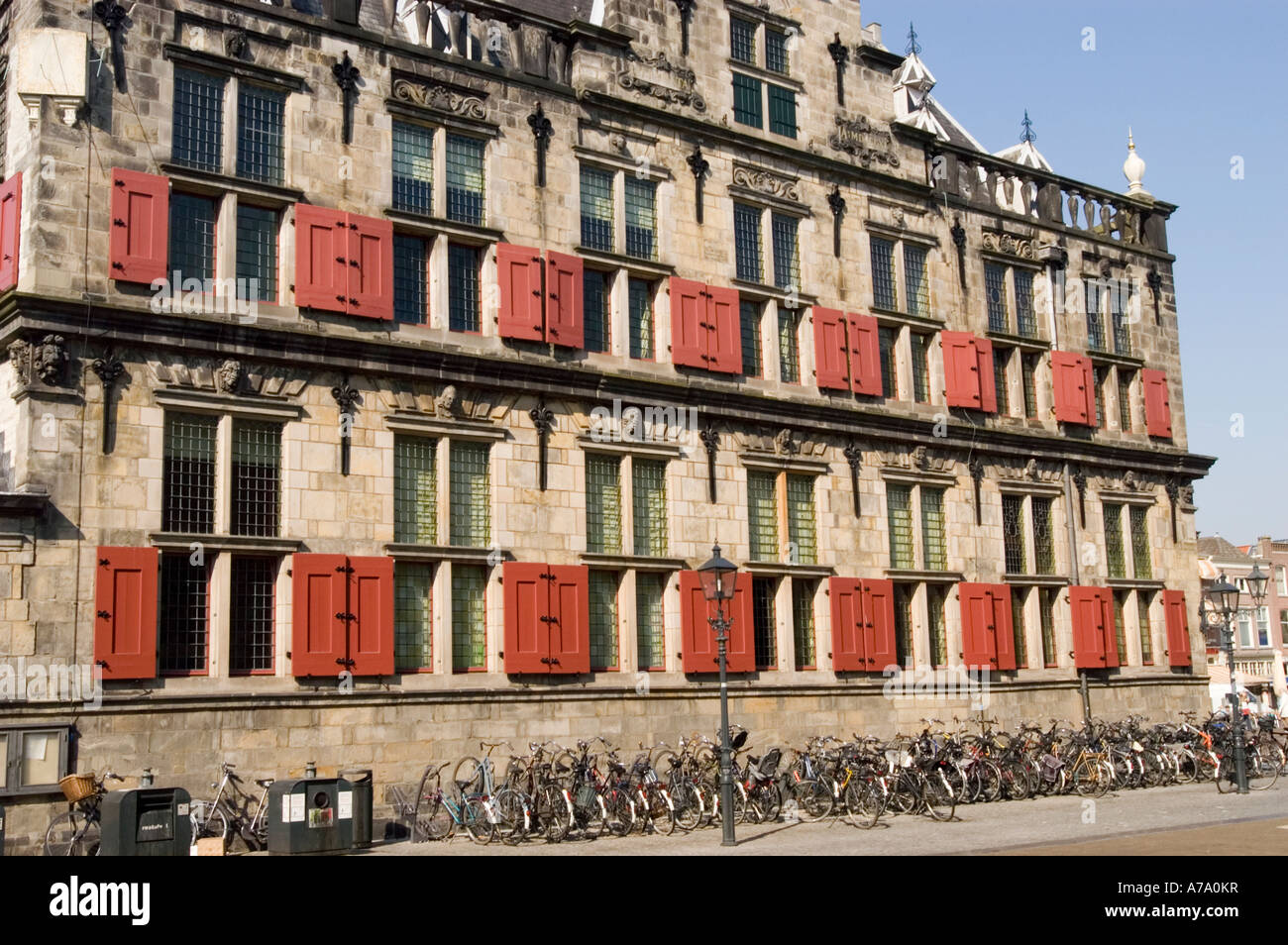 Delft Stadhuis or Townhall with red shutter windows and blue sky ...