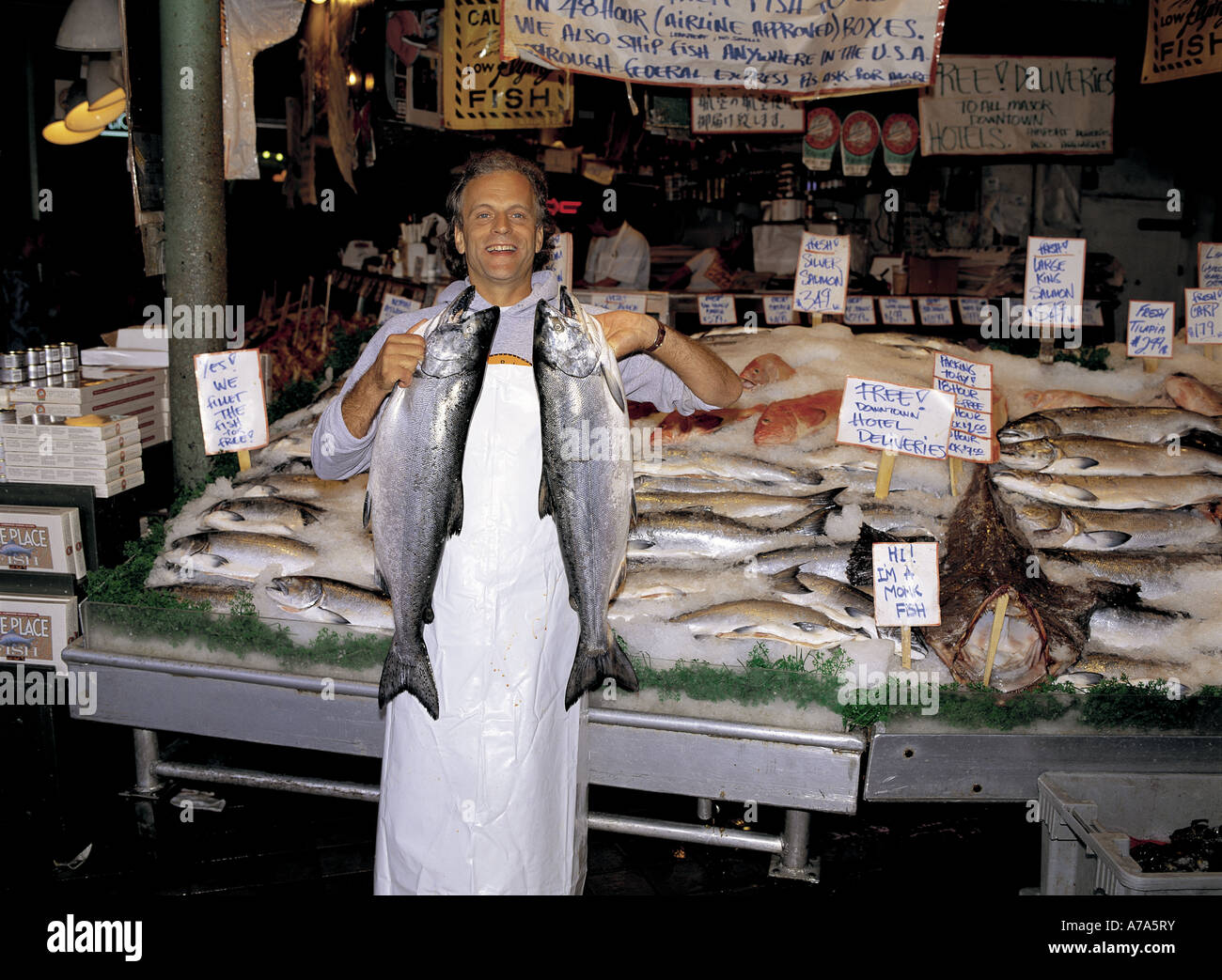 Fishmonger displaying Pacific salmon at fish counter at Pike Street ...