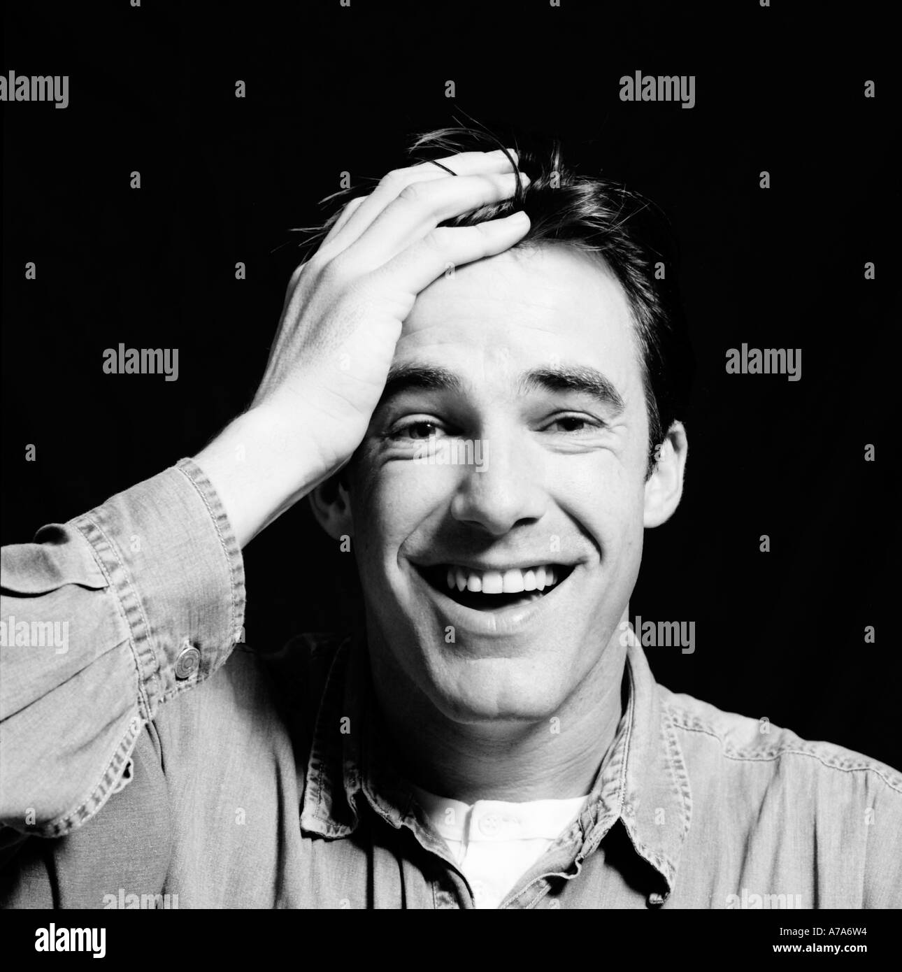 A happy man laughing with his hand on his head Stock Photo - Alamy